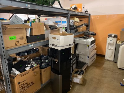 One aisle of random electronics including projectors for sale