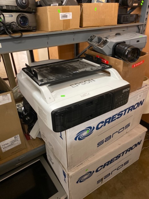 One aisle of random electronics including projectors for sale